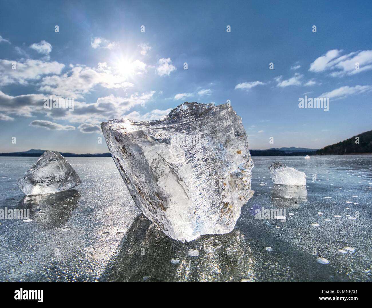 Winter season at frozen river. Shining icicles broken on frozen milky ...