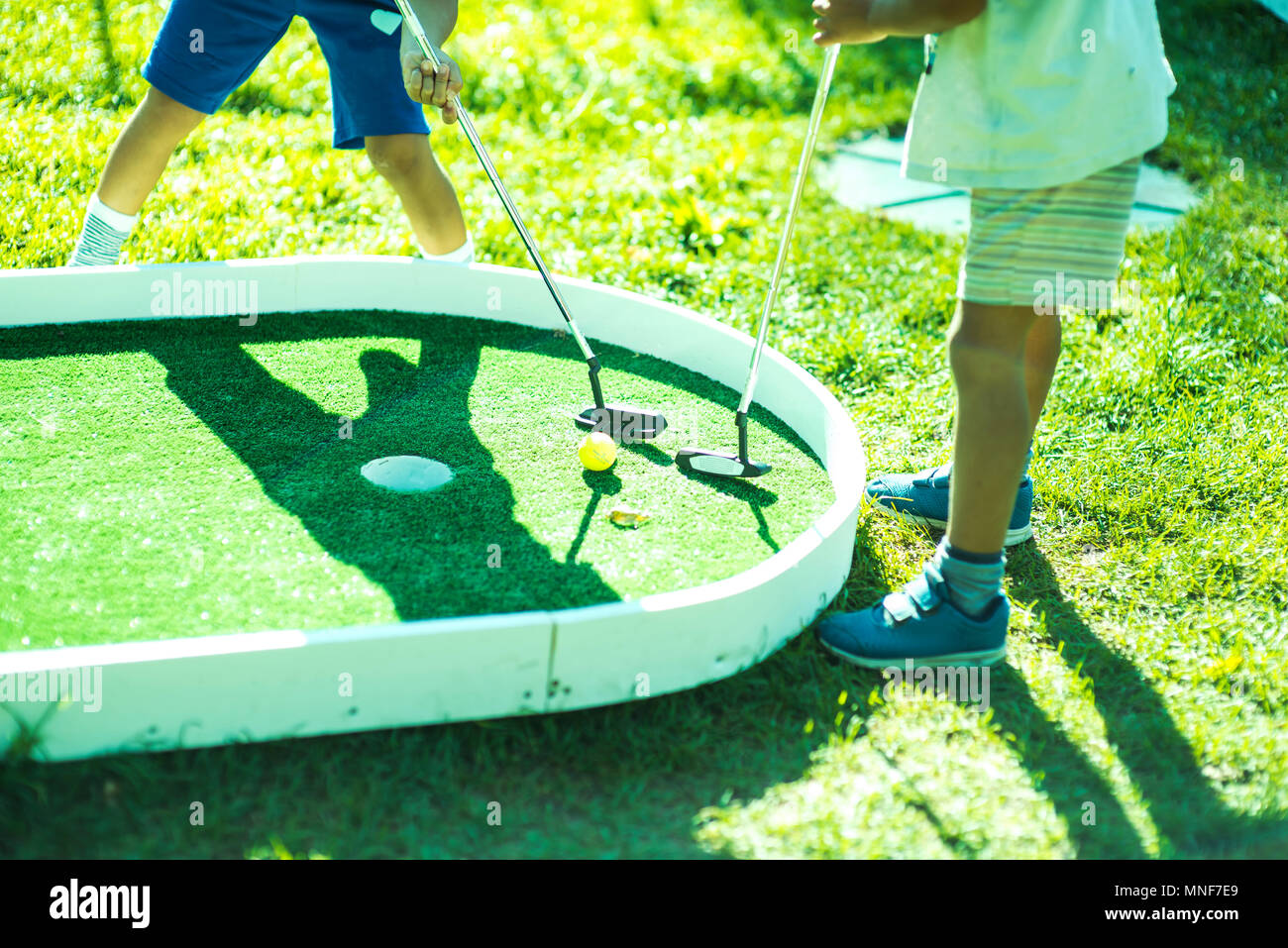 Kids playing golf on a sunny day Stock Photo - Alamy