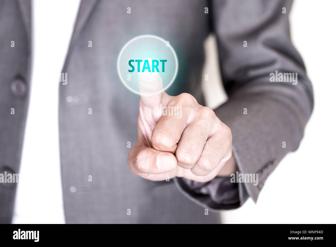 Businessman in gray suit pushing start button on touch screen interface ...