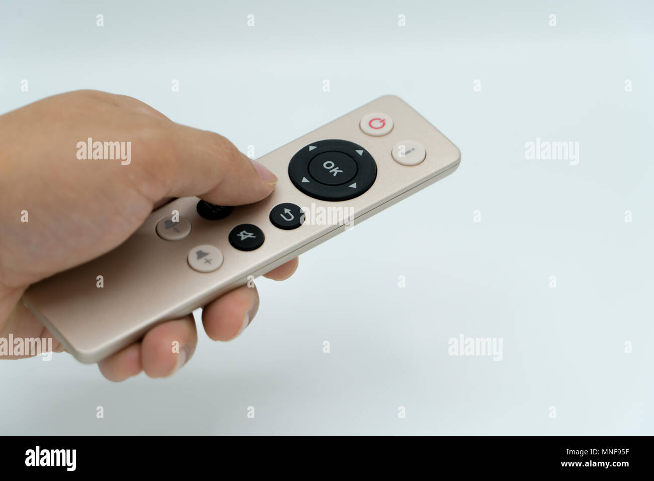 isolate hand control the TV/Media remote control gold color Stock Photo ...