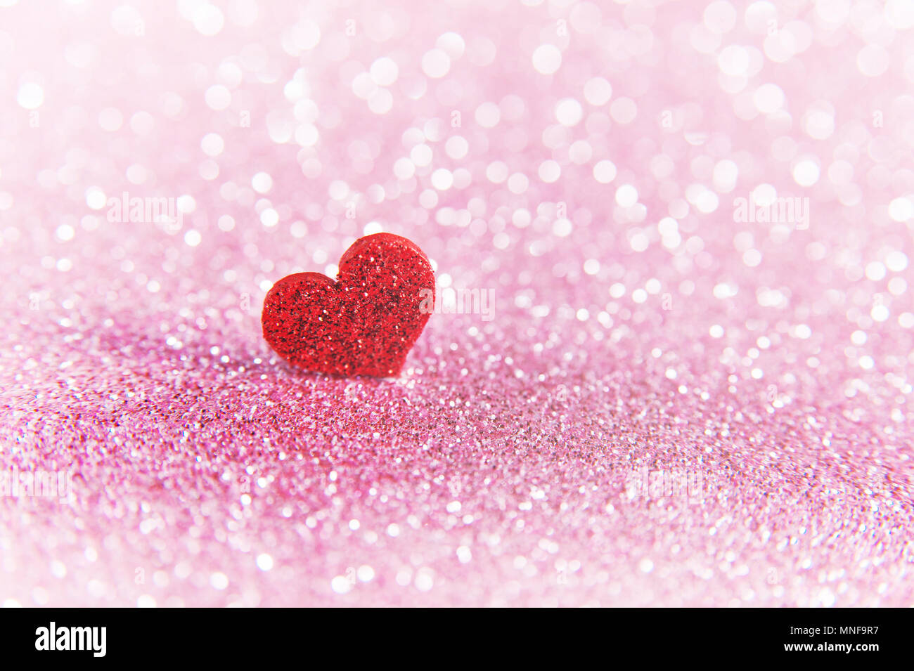 Valentines bright red heart on a pink glitter background Stock Photo ...