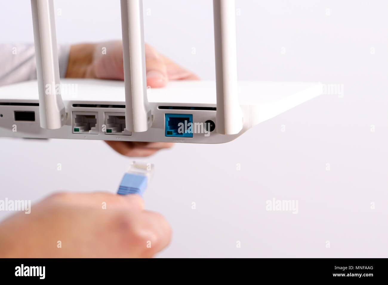 The back view of router showing the lan internet port, and the hand is ...