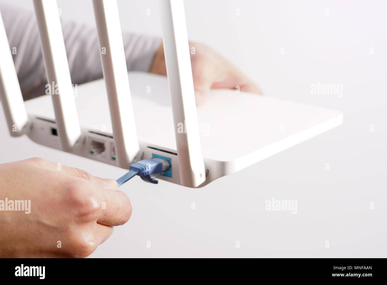 The back view of router showing the lan internet port, and the hand is ...