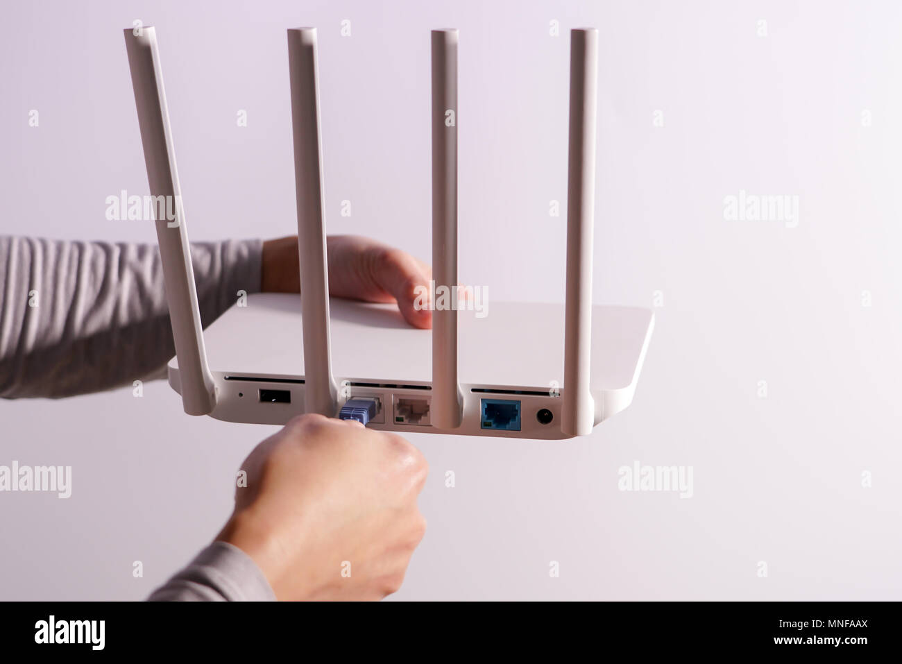 The back view of router showing the lan internet port, and the hand is ...