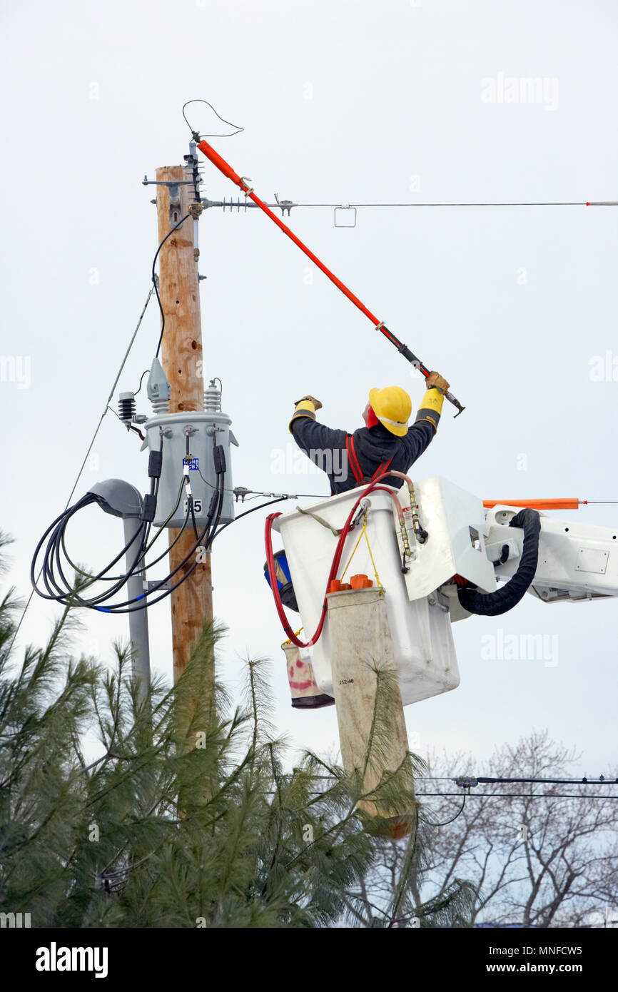 Utility company line man working from a bucket lift to repair and ...