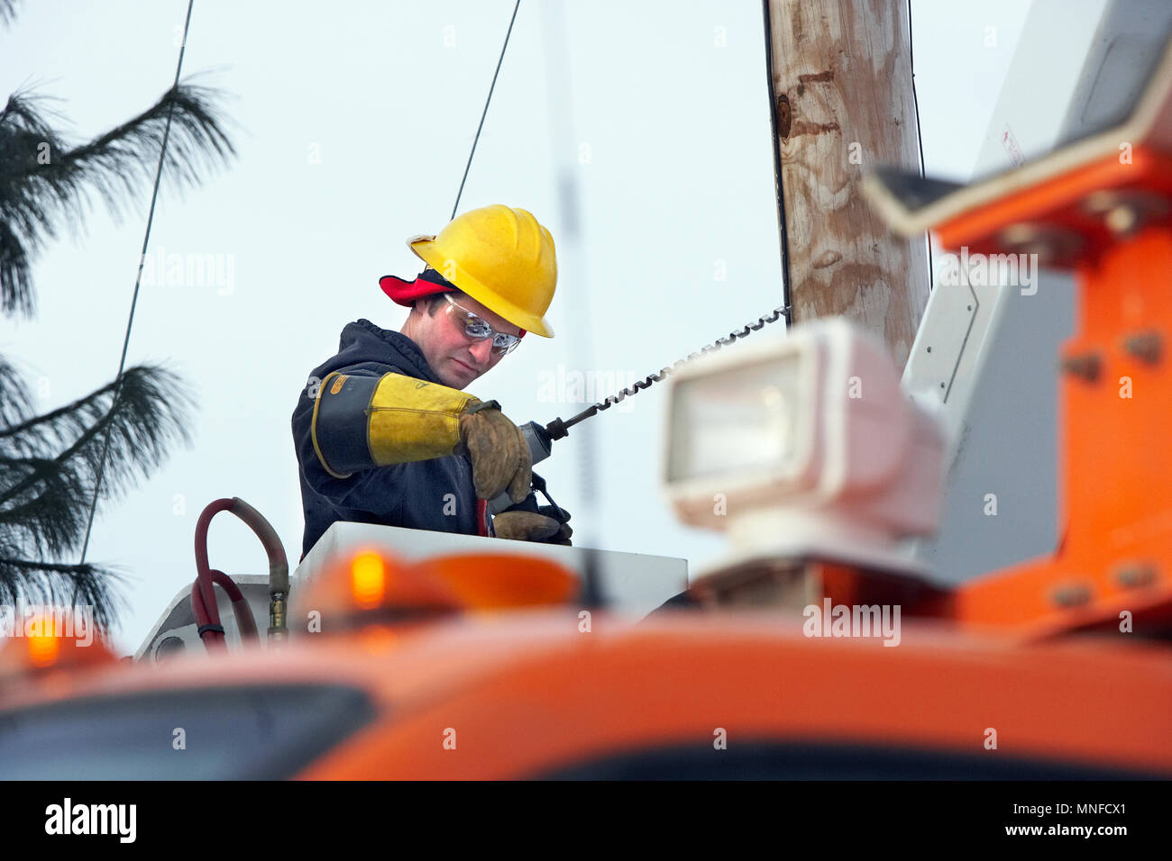 Utility company line man working from a bucket lift to repair and ...
