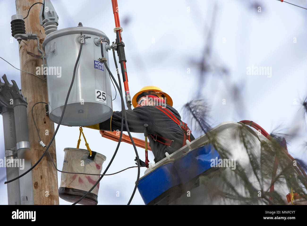 Utility company line man working from a bucket lift to repair and ...