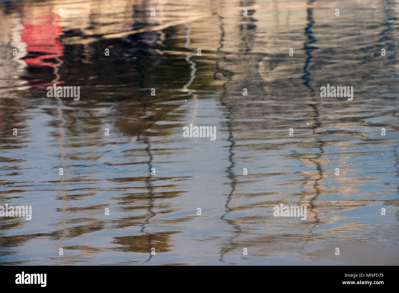 Abstract reflection on the surface of a blue puddle, red and black ...