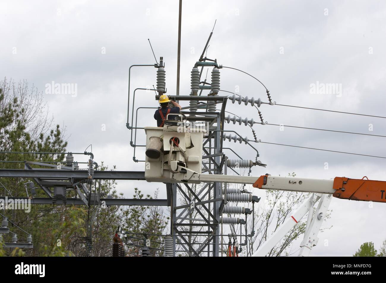 Utility company line man working from a bucket lift to repair and ...