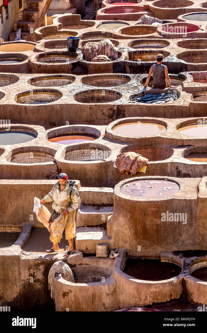 Workers using the hot, old and difficult traditional methods of tanning ...