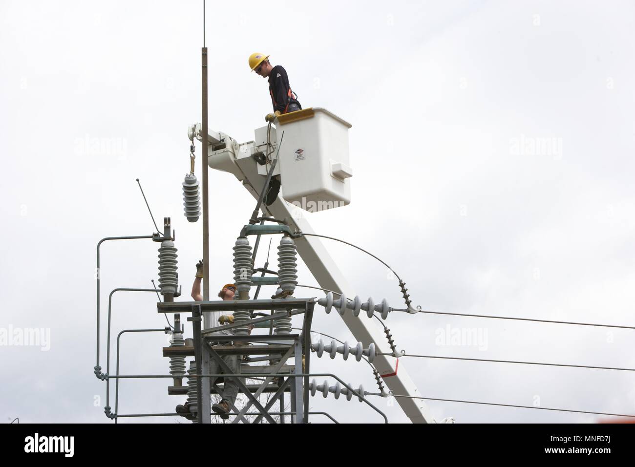 Utility company line man working from a bucket lift to repair and ...
