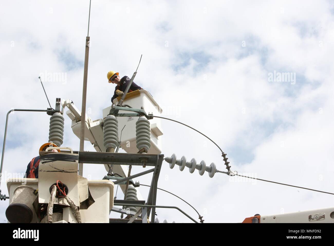 Utility company line man working from a bucket lift to repair and ...