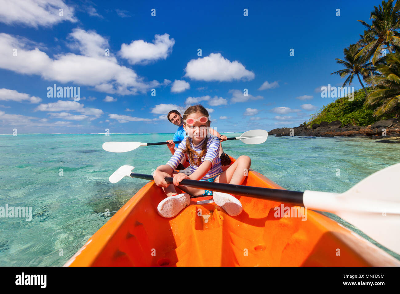 Kids enjoying paddling in colorful red kayak at tropical ocean water ...