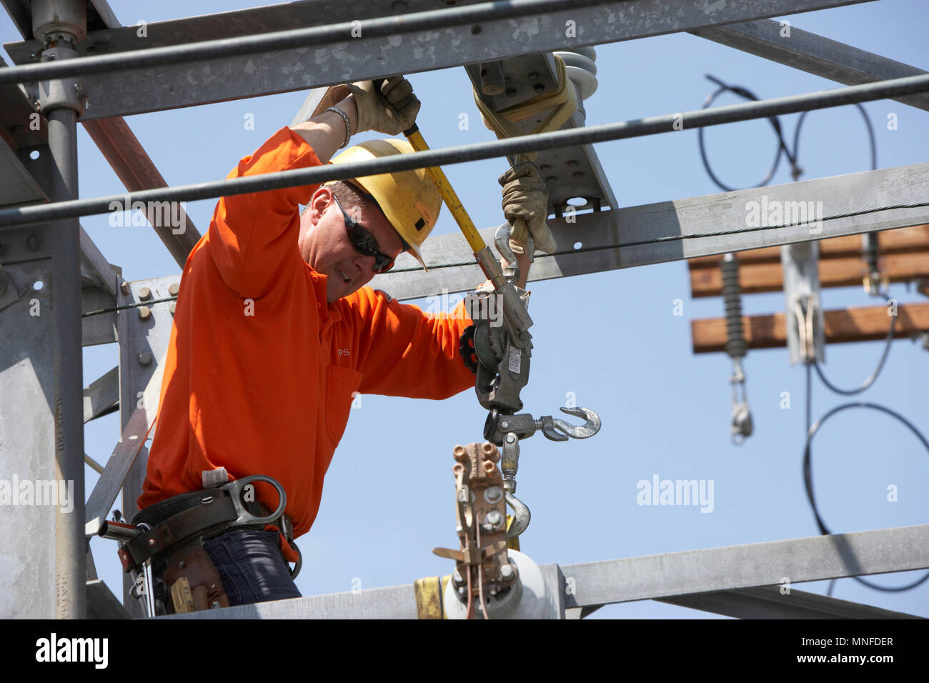 Utility workman wearing hardhat installing new equipment on an ...