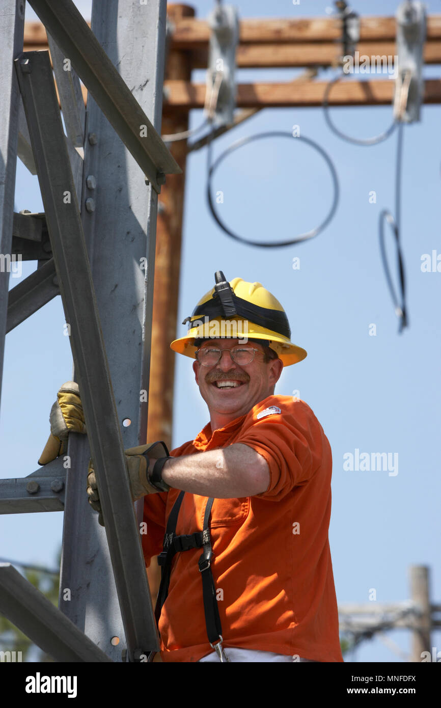 Portrait of a utility workman wearing safety harness and hardhat ...