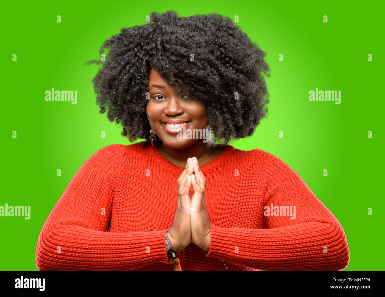 Beautiful african woman with hands together in praying gesture ...