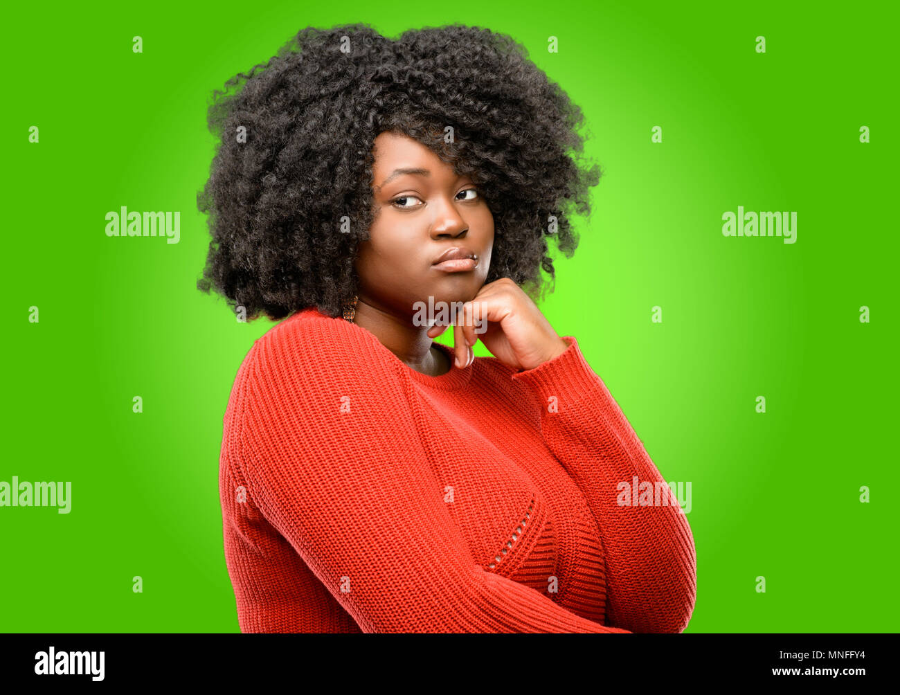 Beautiful african woman thinking and looking up expressing doubt and ...