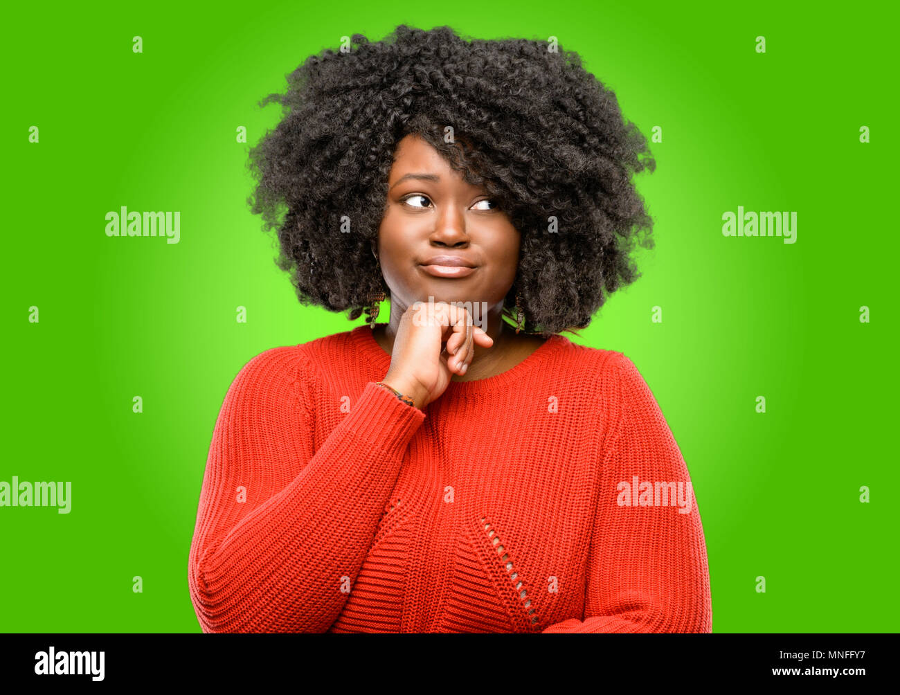 Beautiful african woman thinking and looking up expressing doubt and ...
