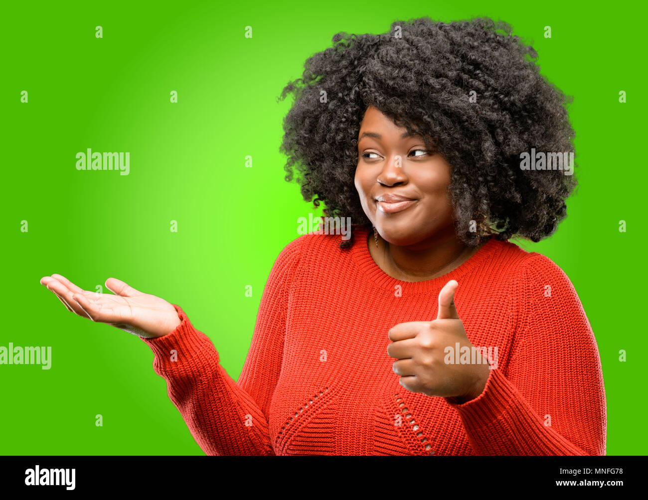 Beautiful african woman thumb up holding something in his empty hand ...