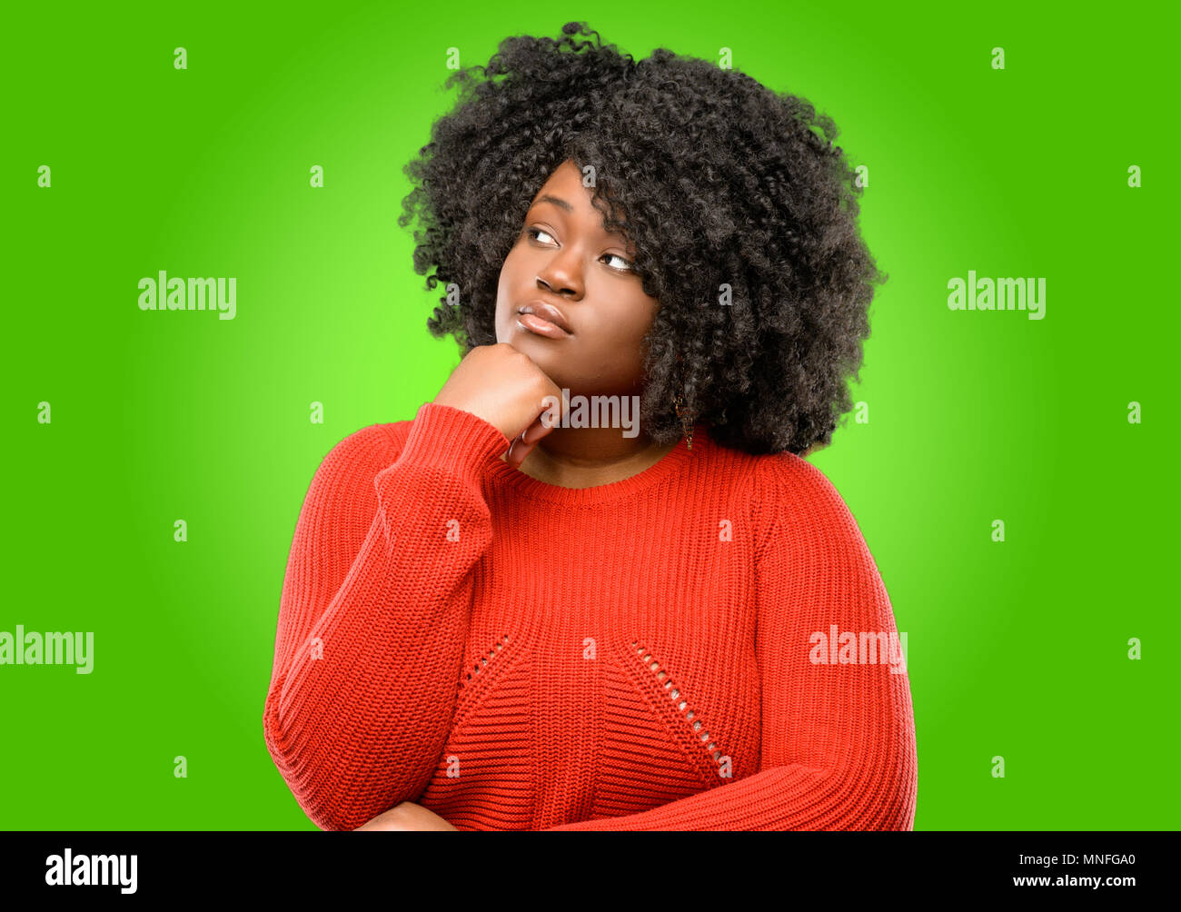 Beautiful african woman thinking and looking up expressing doubt and ...
