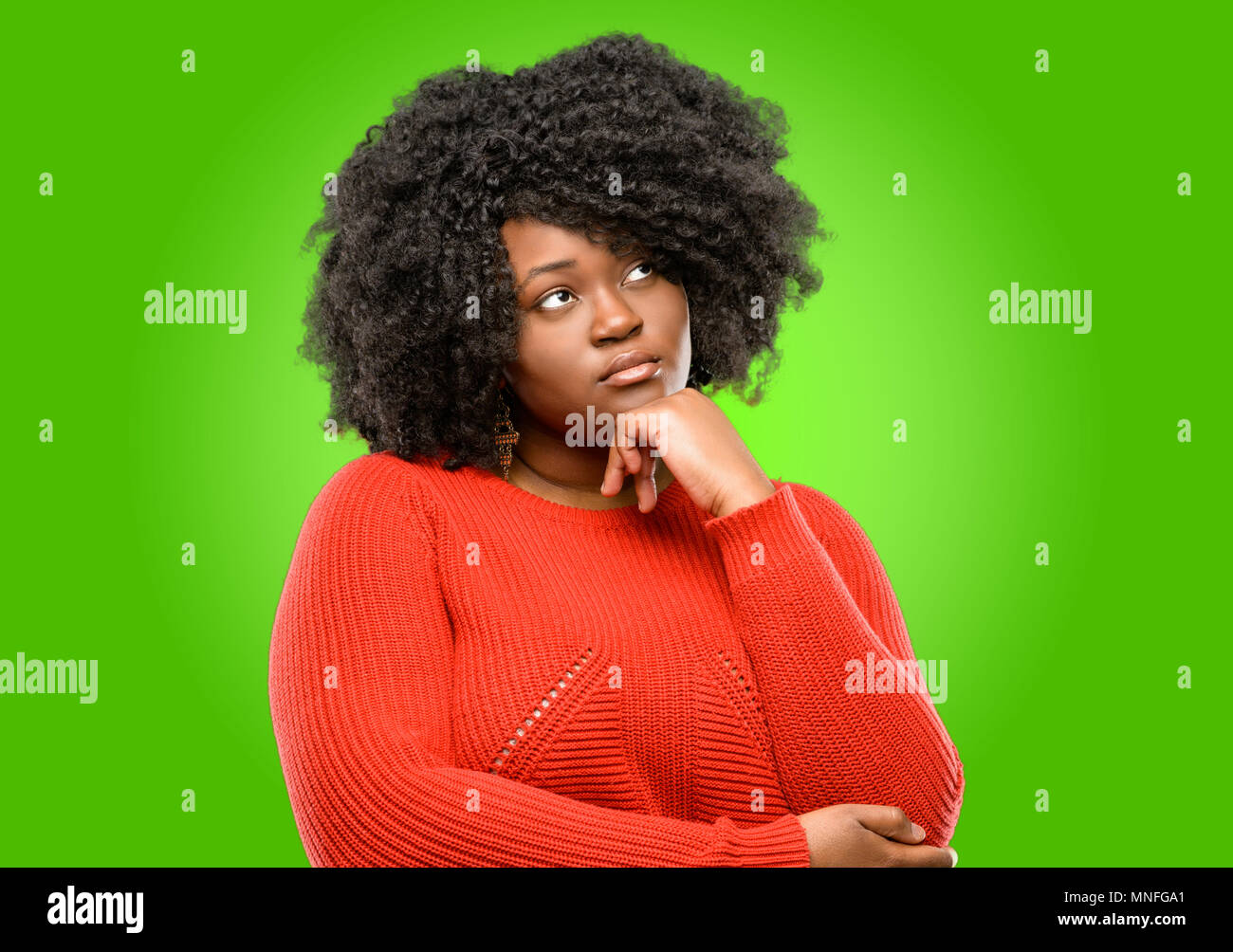 Beautiful african woman thinking and looking up expressing doubt and ...