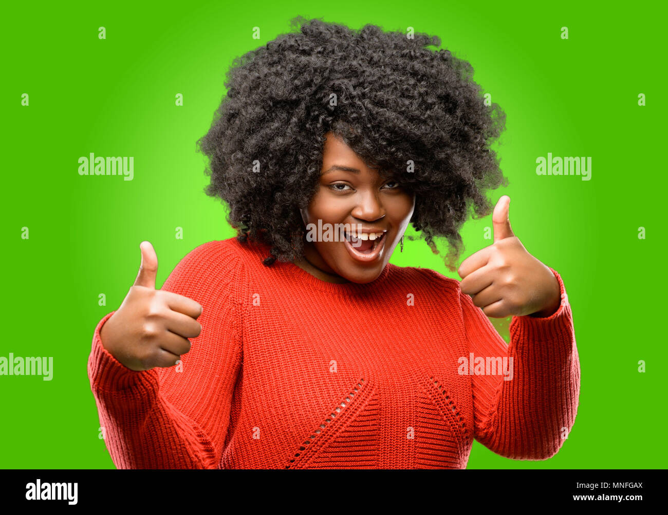 Beautiful african woman smiling broadly showing thumbs up gesture to ...