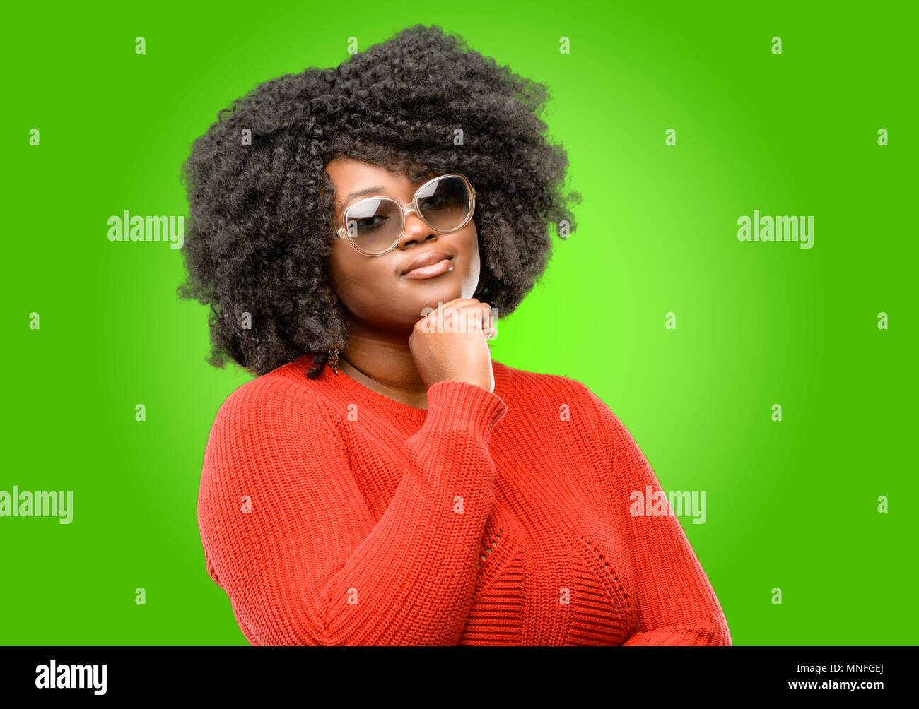 Beautiful african woman thinking and looking up expressing doubt and ...
