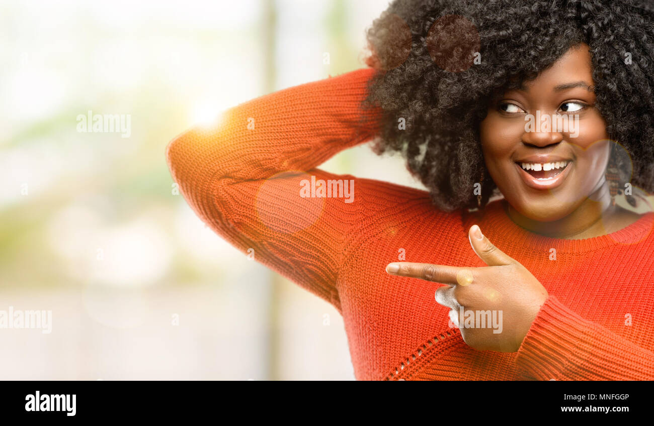 Beautiful african woman pointing away side with his finger, outdoor ...