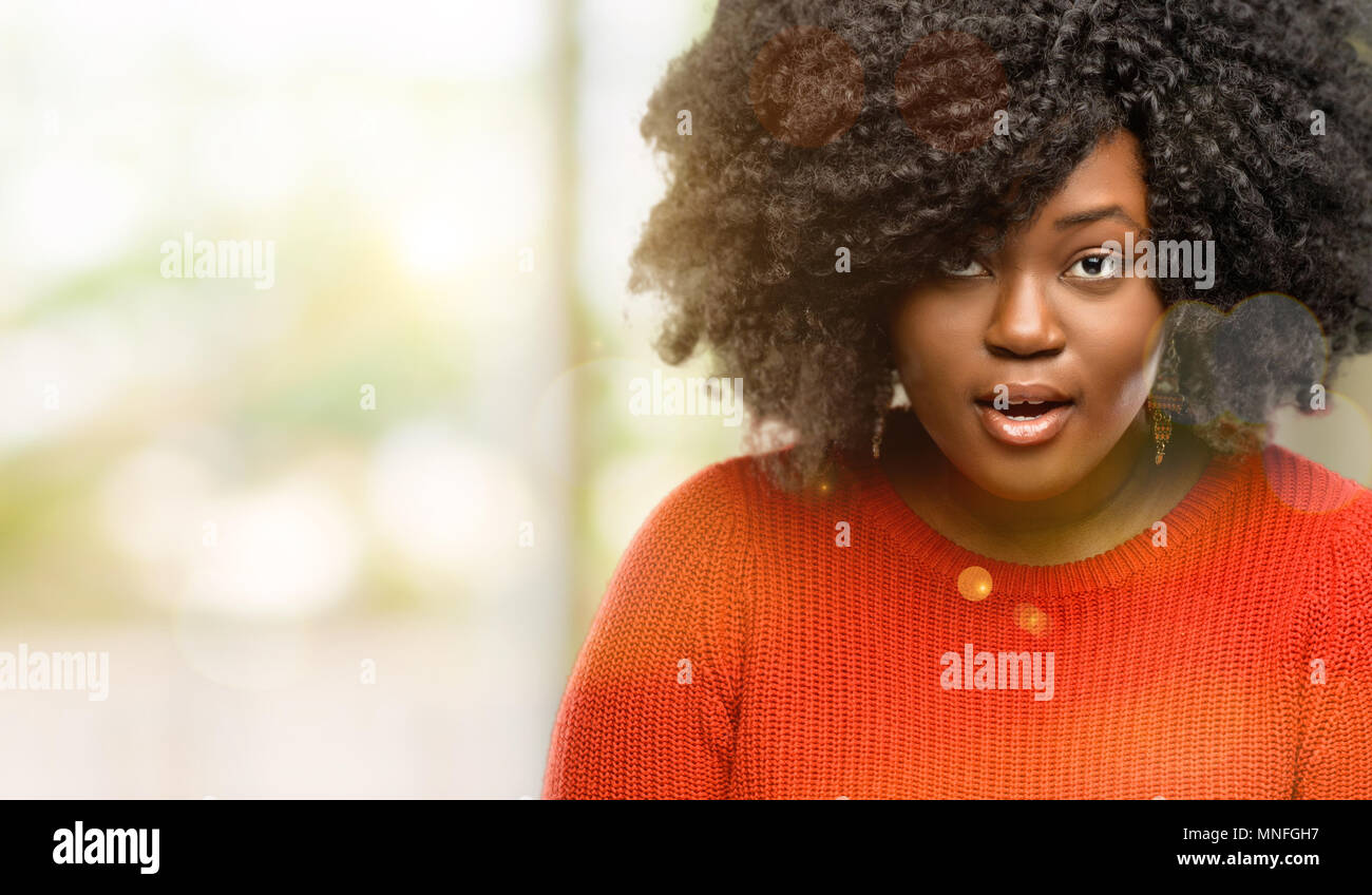 Beautiful african woman scared in shock, expressing panic and fear ...