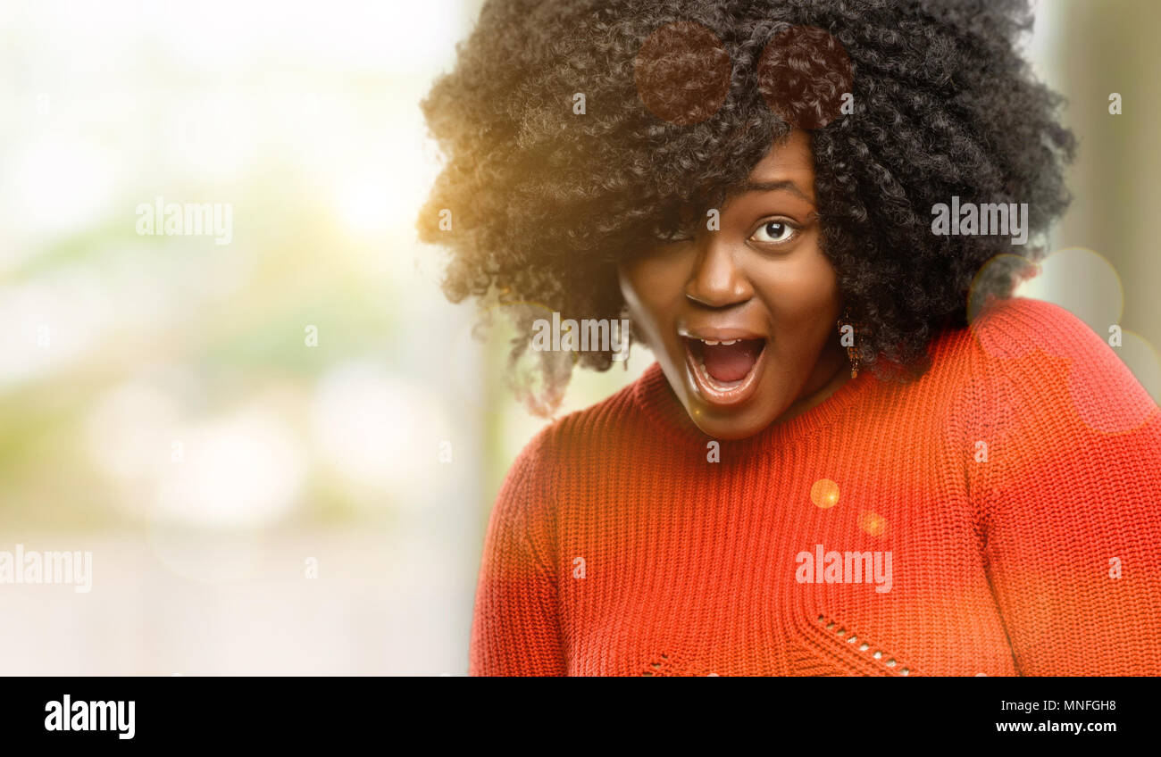 Beautiful african woman scared in shock, expressing panic and fear ...