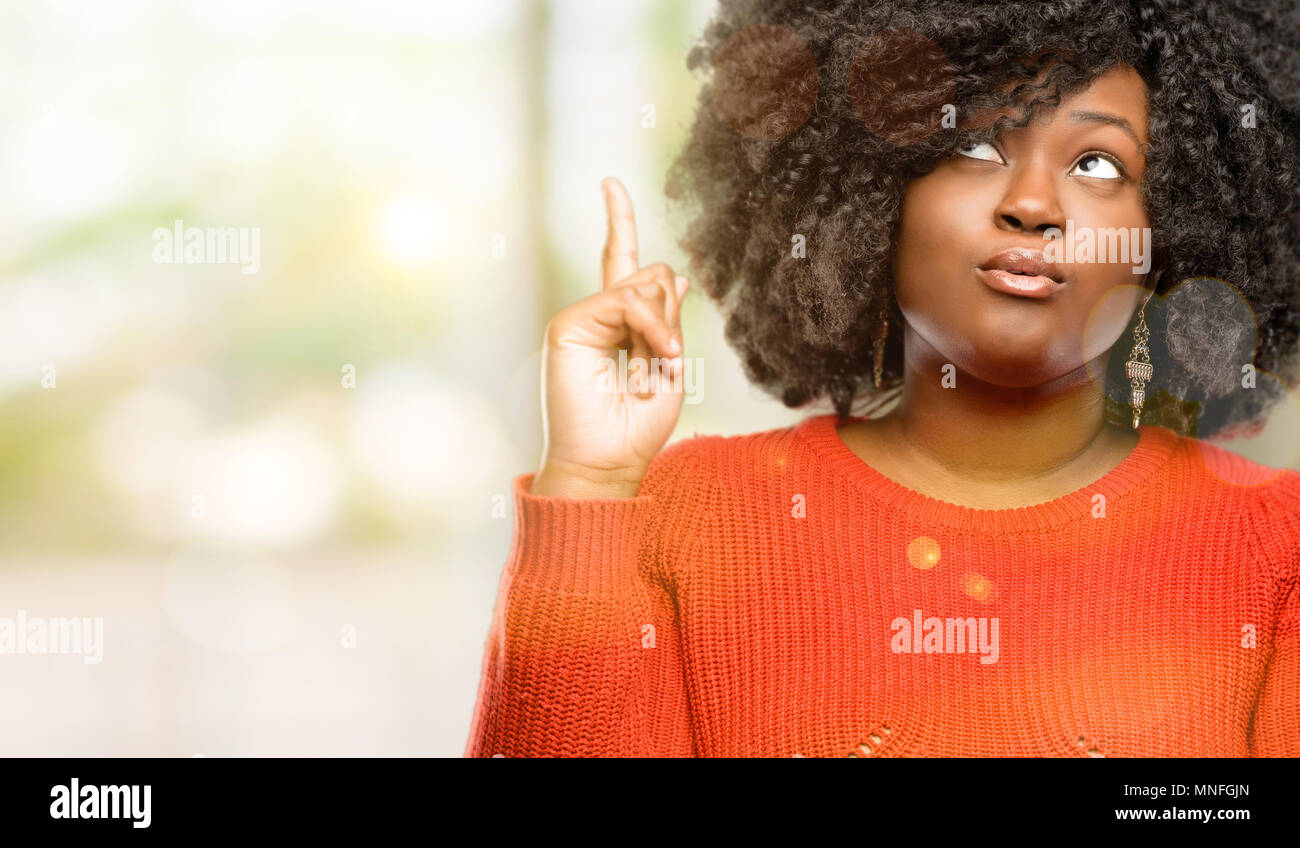 Beautiful african woman happy and surprised cheering expressing wow ...