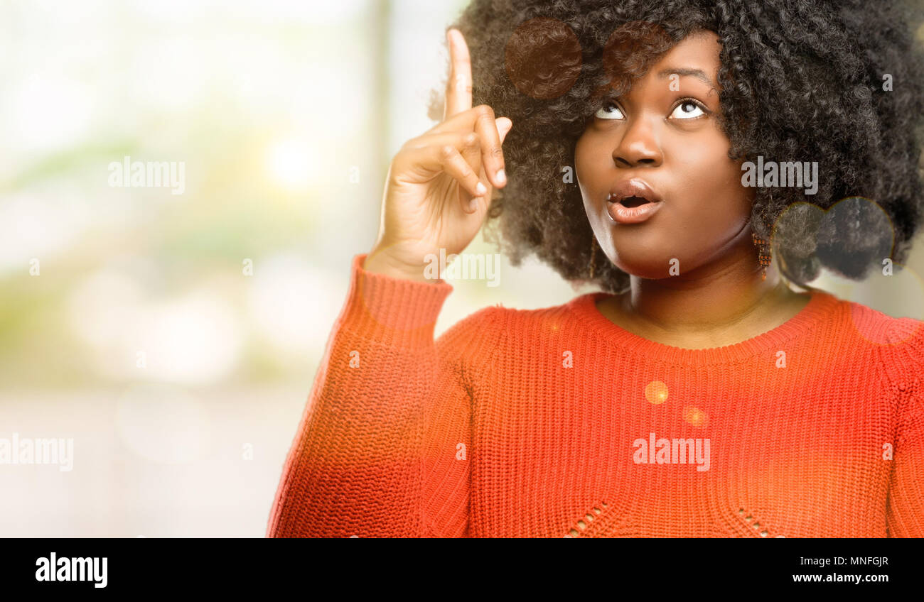 Beautiful african woman happy and surprised cheering expressing wow ...