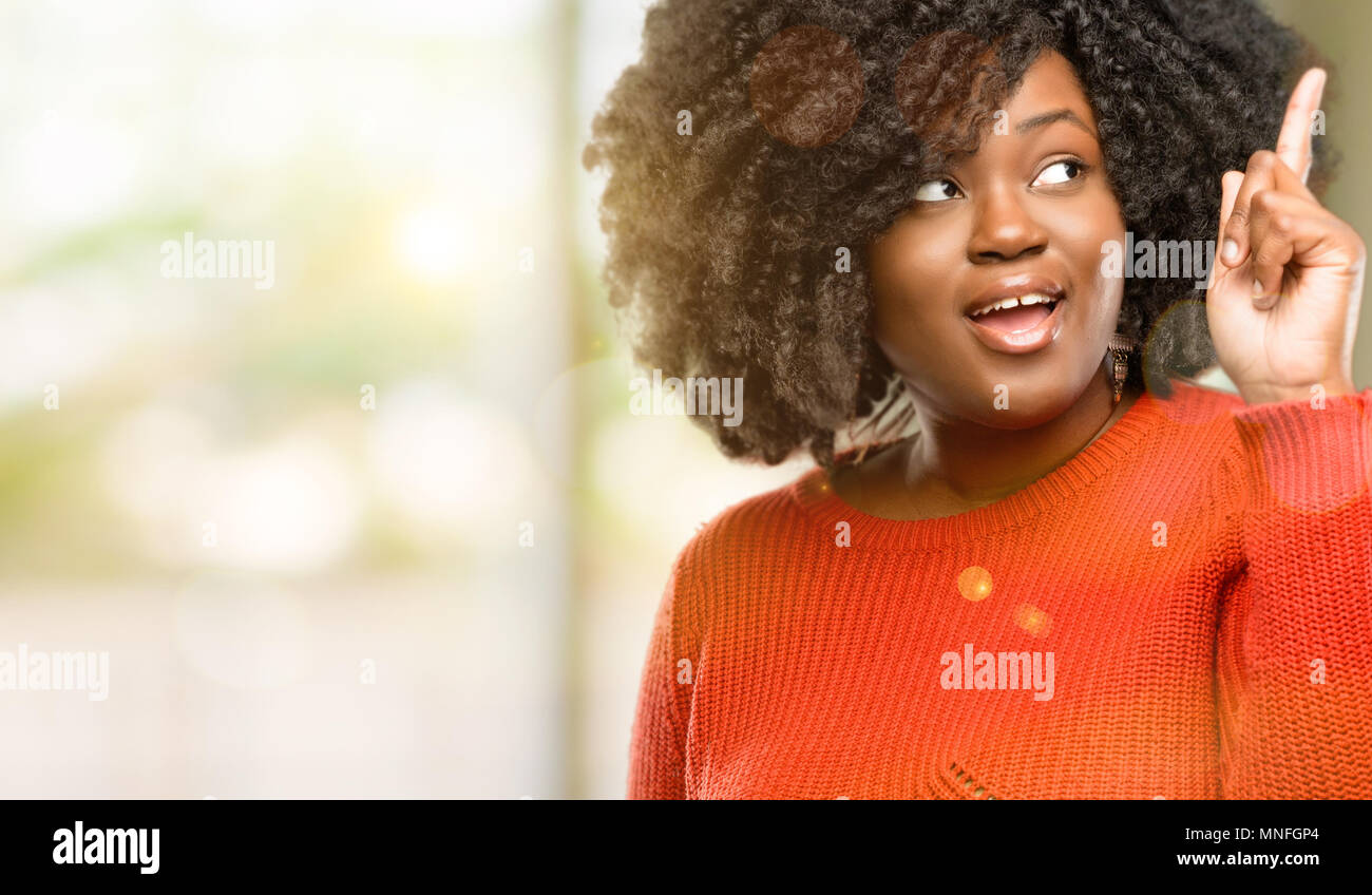 Beautiful african woman happy and surprised cheering expressing wow ...