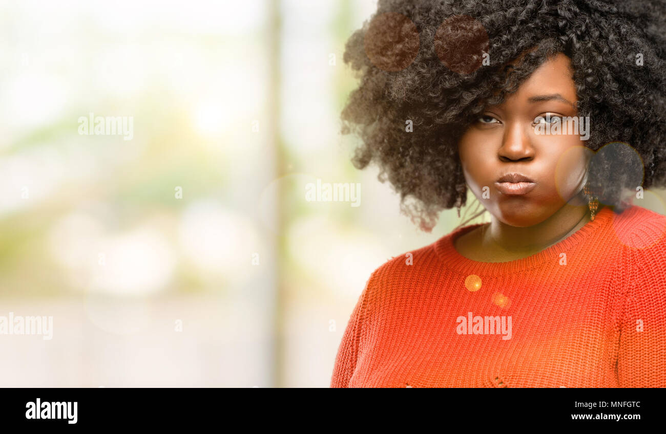 Beautiful african woman puffing out cheeks, having fun making funny ...