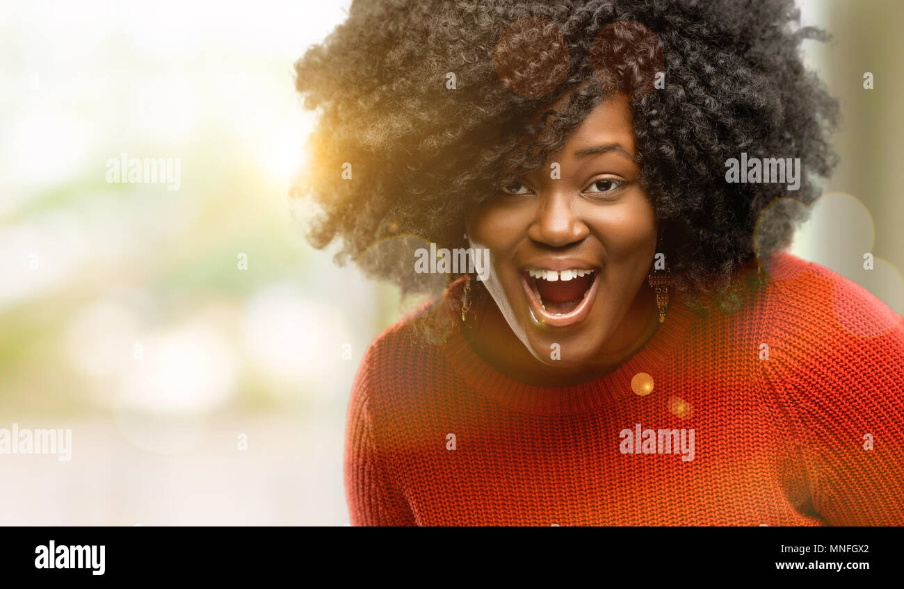Beautiful african woman scared and surprised cheering expressing wow ...