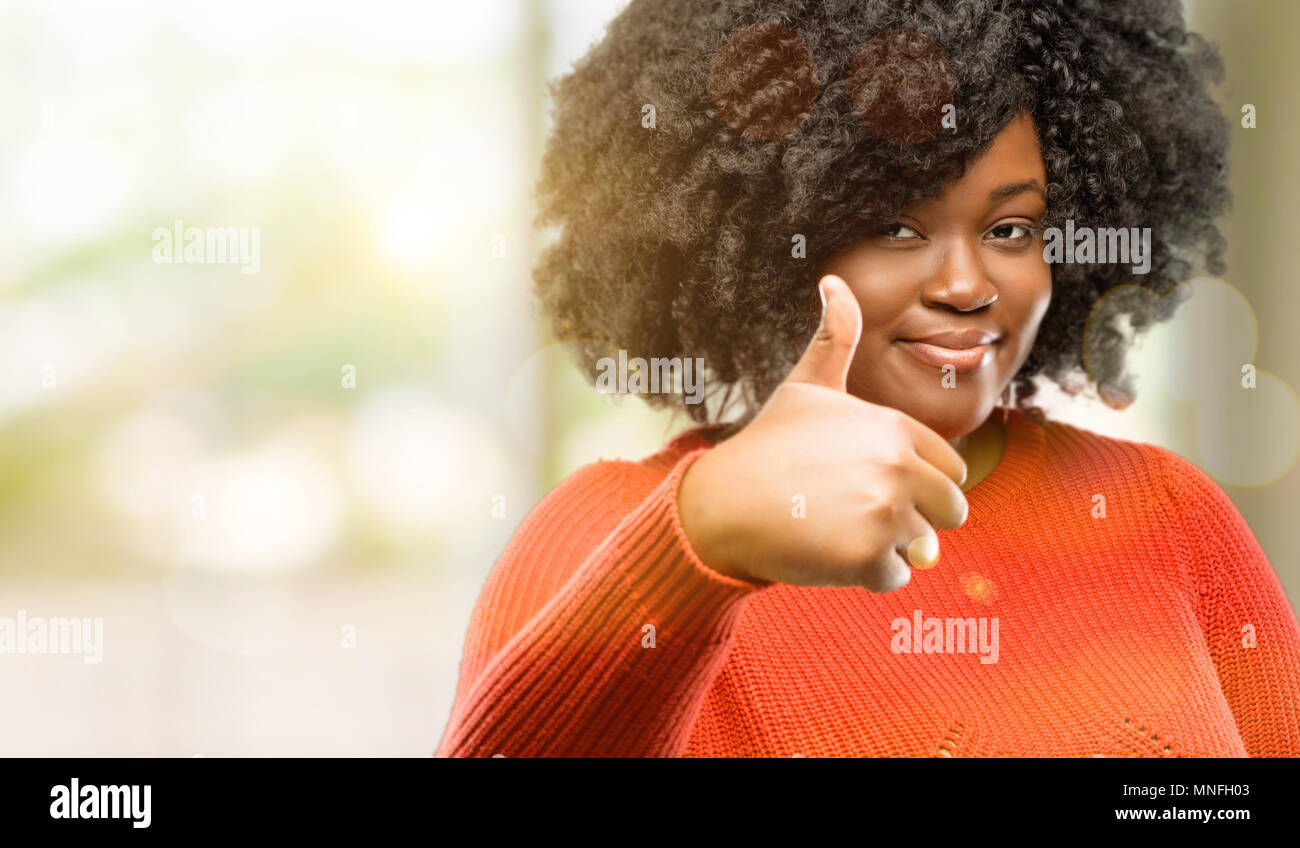 Beautiful african woman smiling broadly showing thumbs up gesture to ...