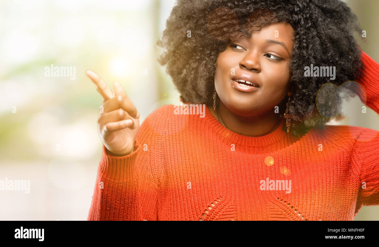 Beautiful african woman pointing away side with his finger, outdoor ...