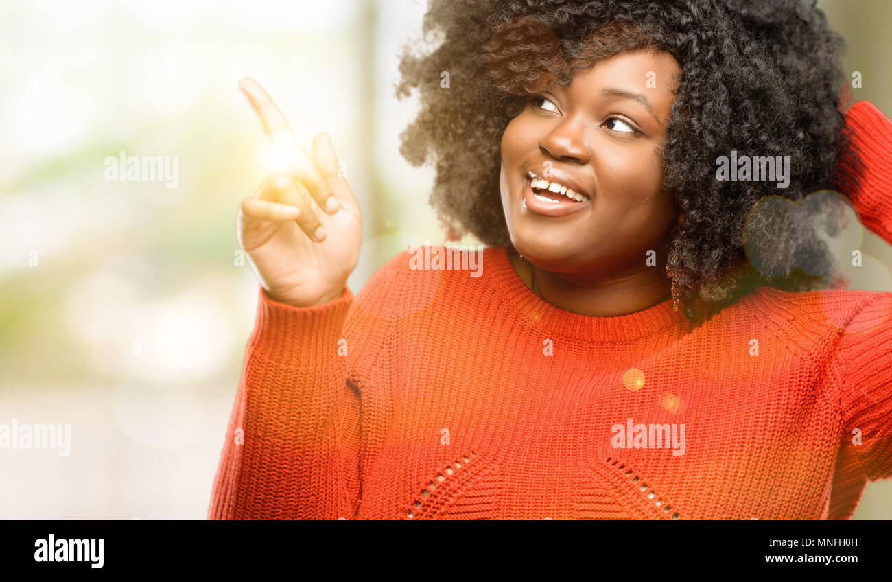 Beautiful african woman pointing away side with his finger, outdoor ...