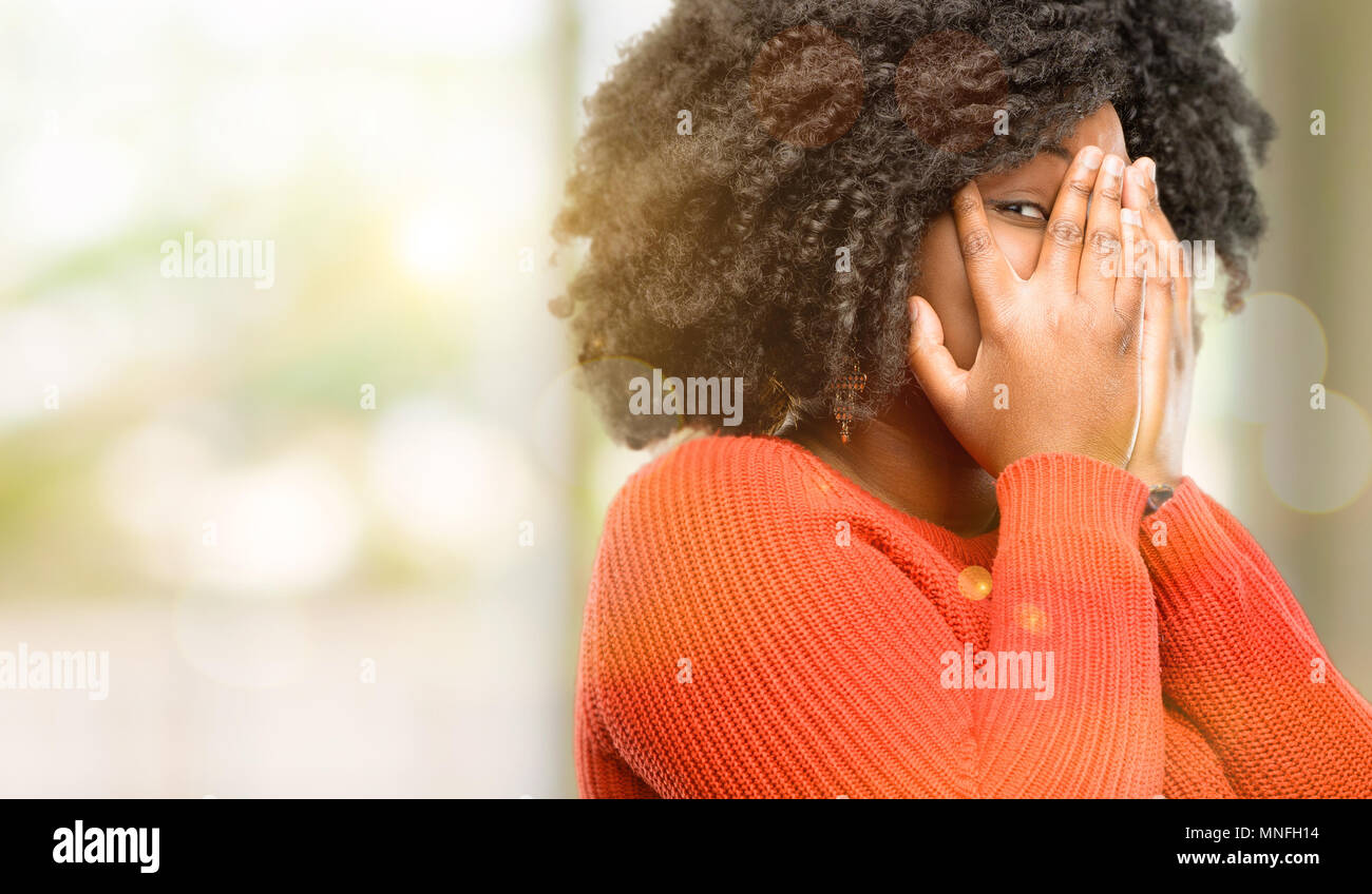 Beautiful african woman smiling having shy look peeking through her ...