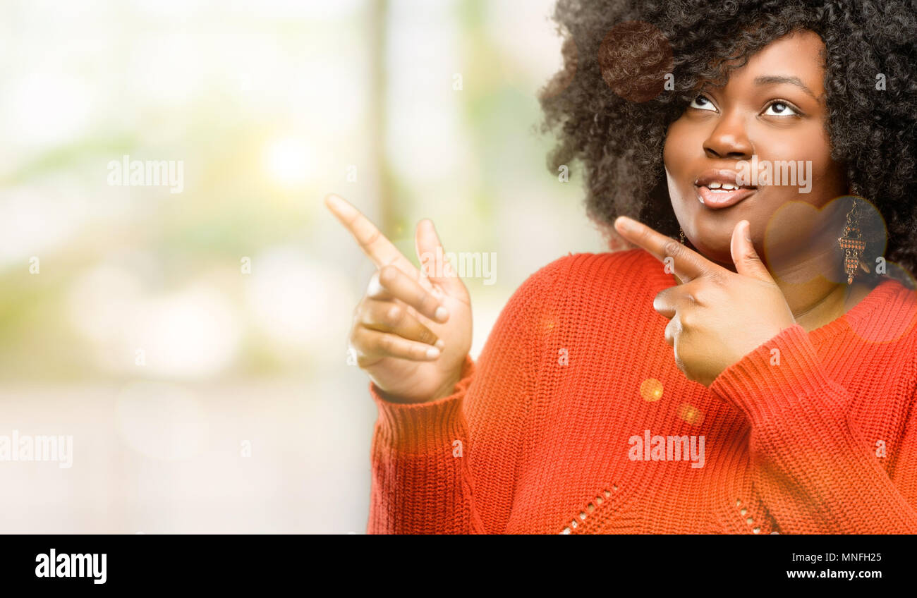 Beautiful african woman pointing away side with his finger, outdoor ...