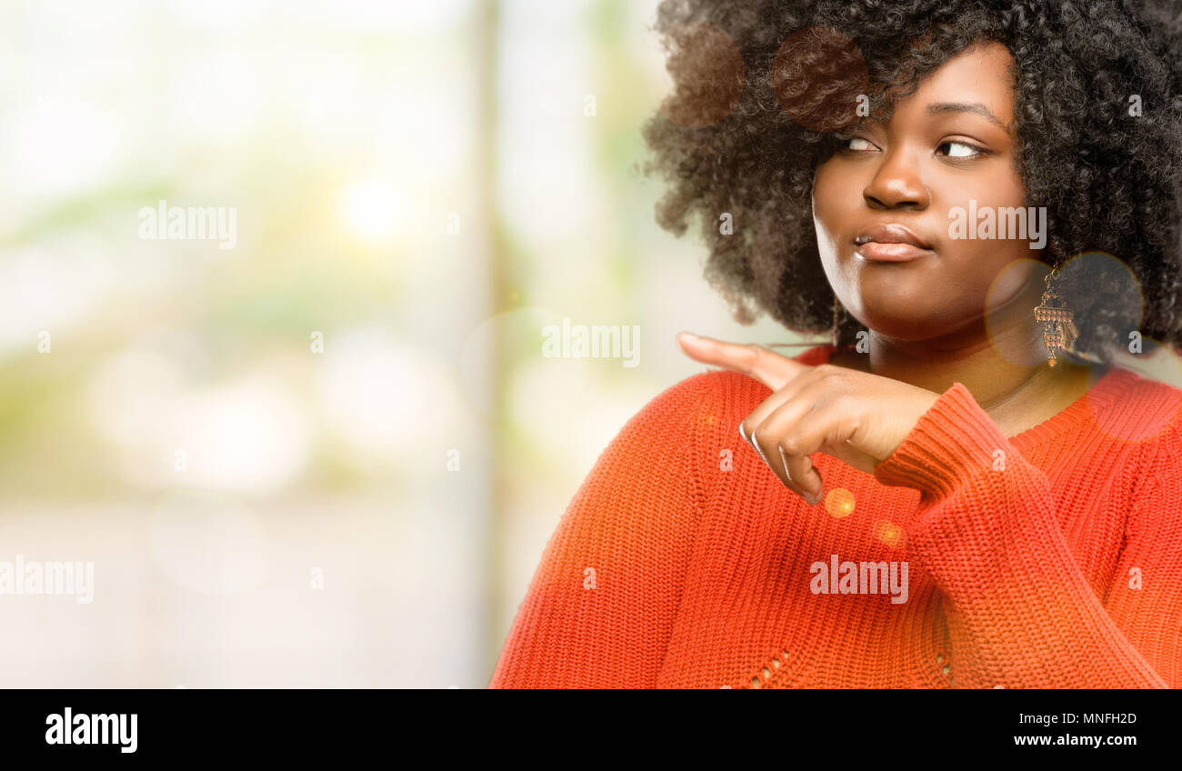 Beautiful african woman pointing away side with his finger, outdoor ...