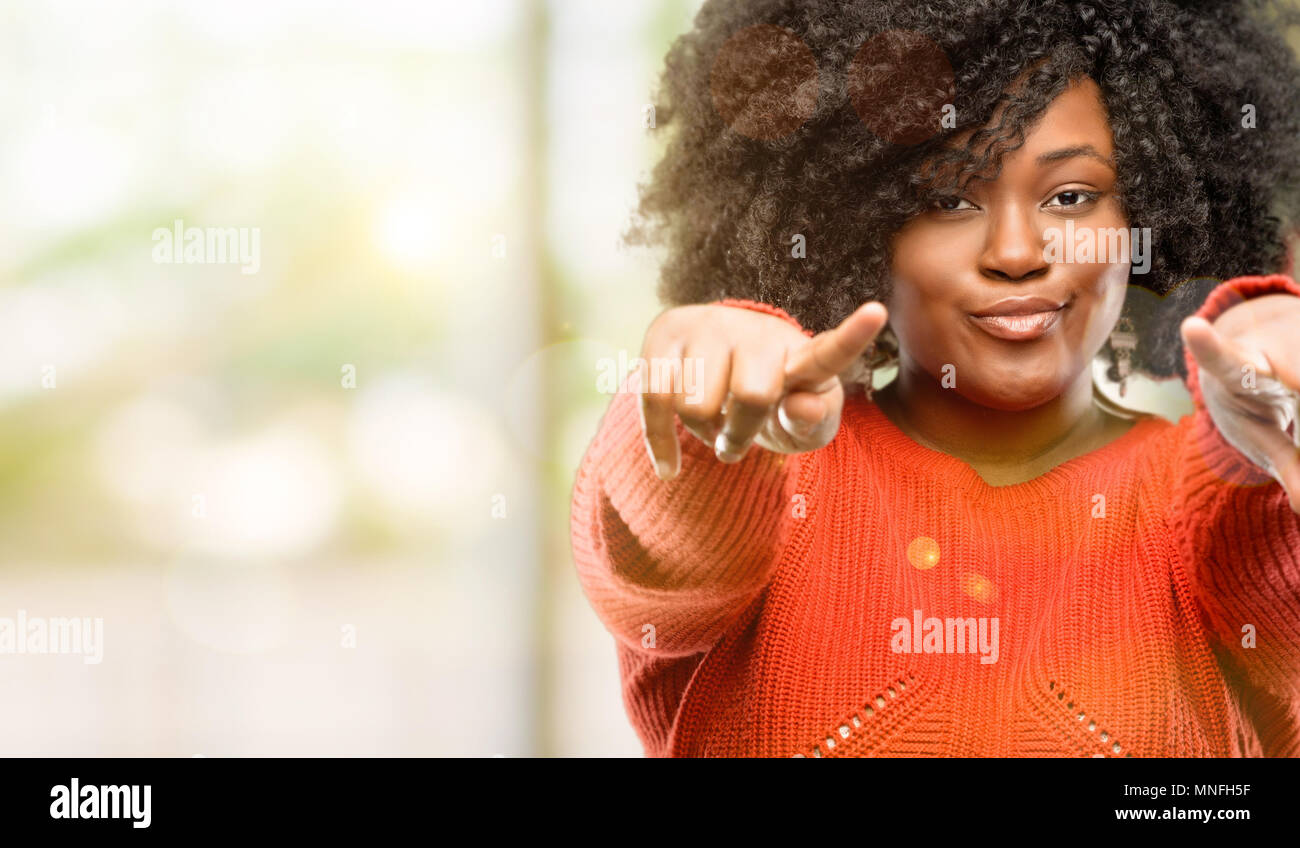Beautiful african woman pointing to the front with finger, outdoor ...
