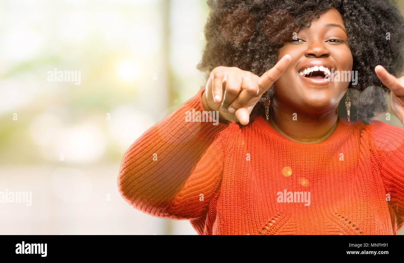 Beautiful african woman pointing to the front with finger, outdoor ...