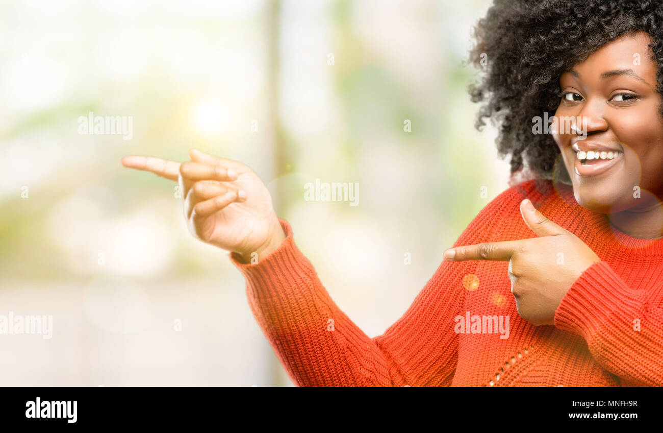 Beautiful african woman pointing away side with finger, outdoor Stock ...