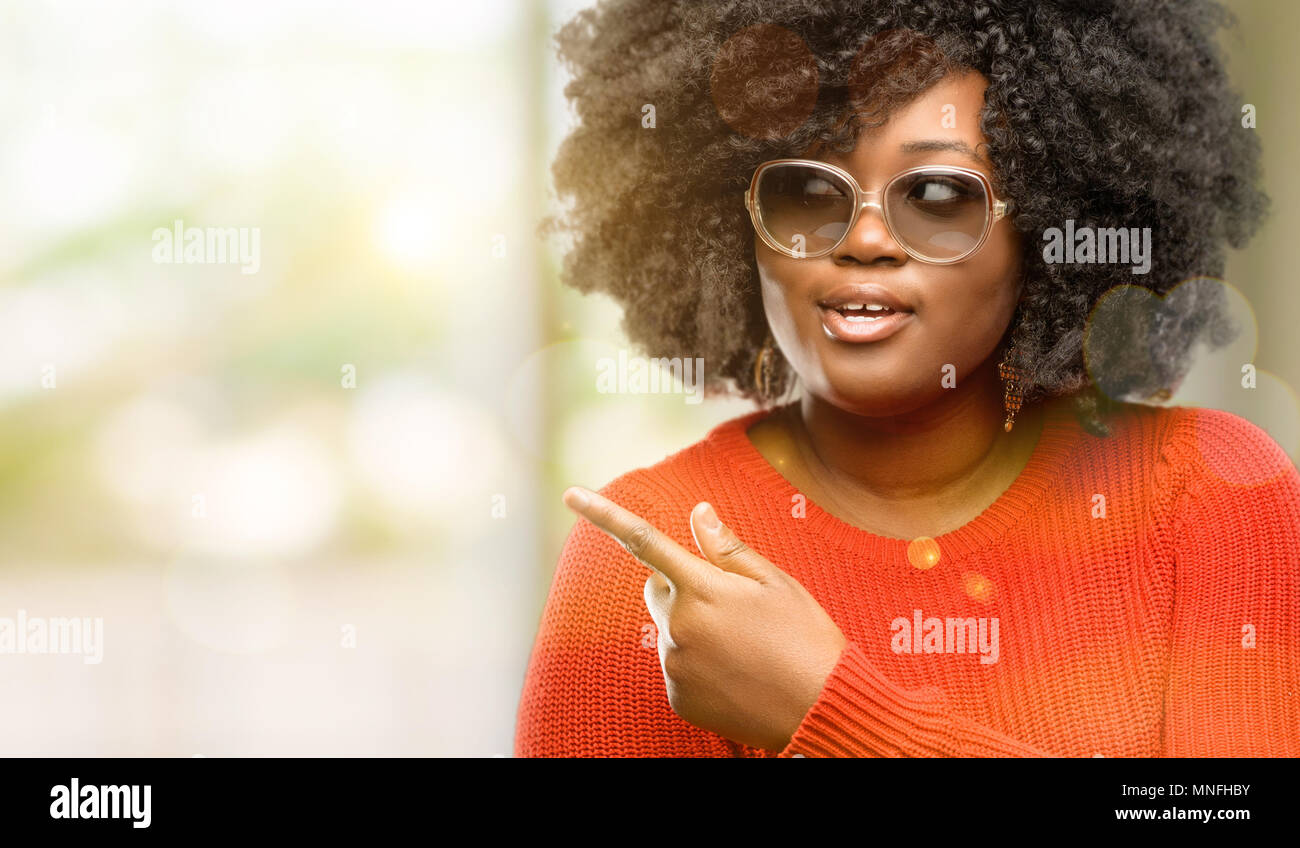 Beautiful african woman pointing away side with finger, outdoor Stock ...