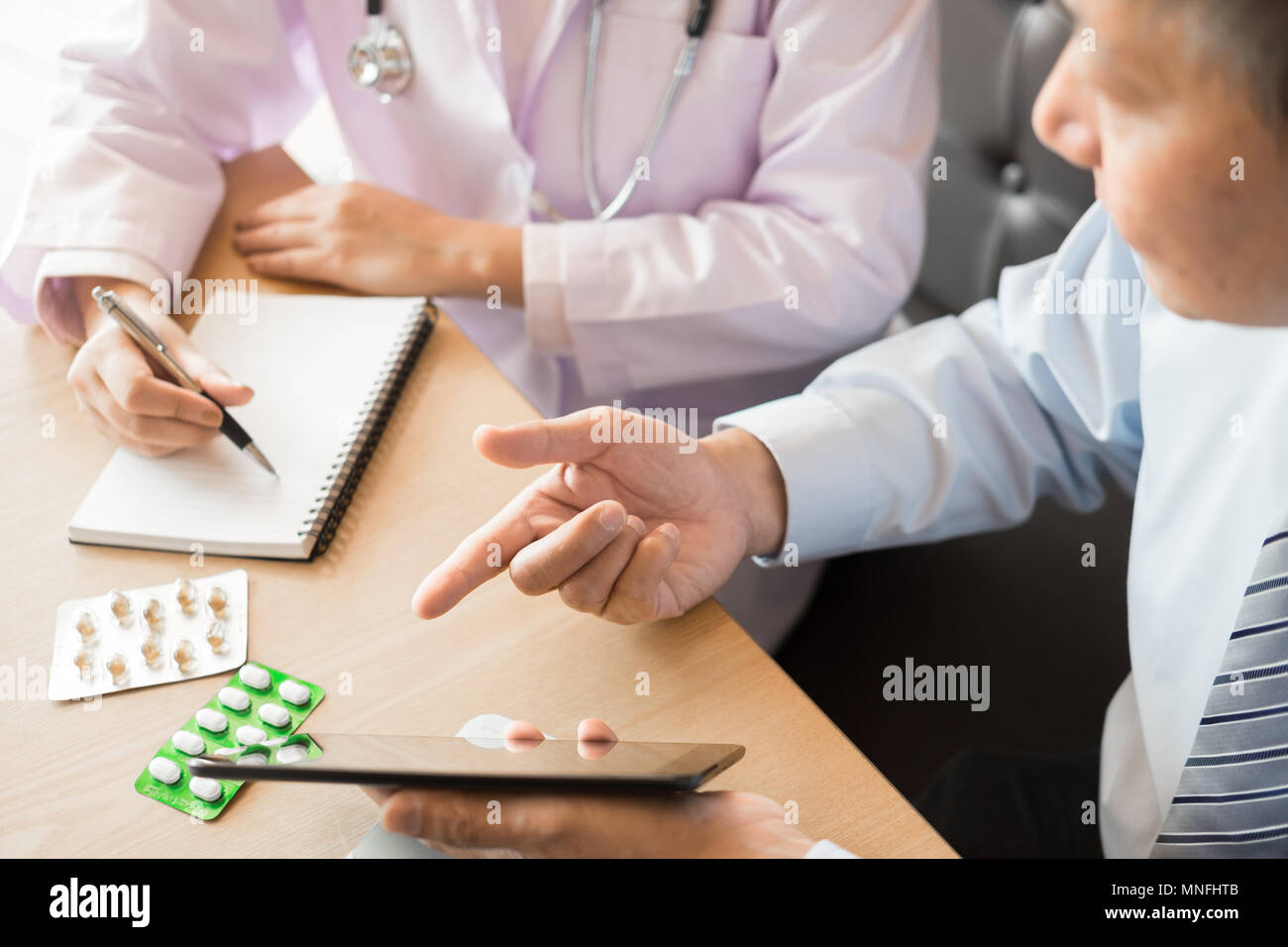 doctor hand holding tablet of drug and explain to patient in hospital ...