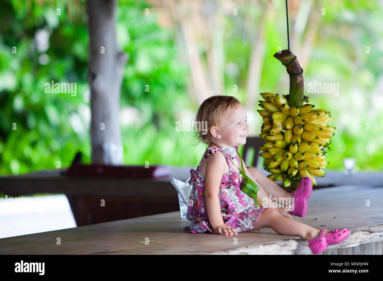 Adorable toddler girl outdoors with bunch of bananas Stock Photo - Alamy