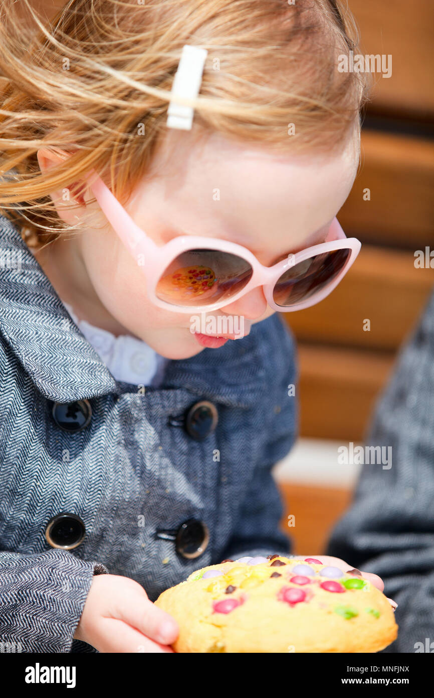 Portrait of cute little girls outdoors eating big cookie Stock Photo ...