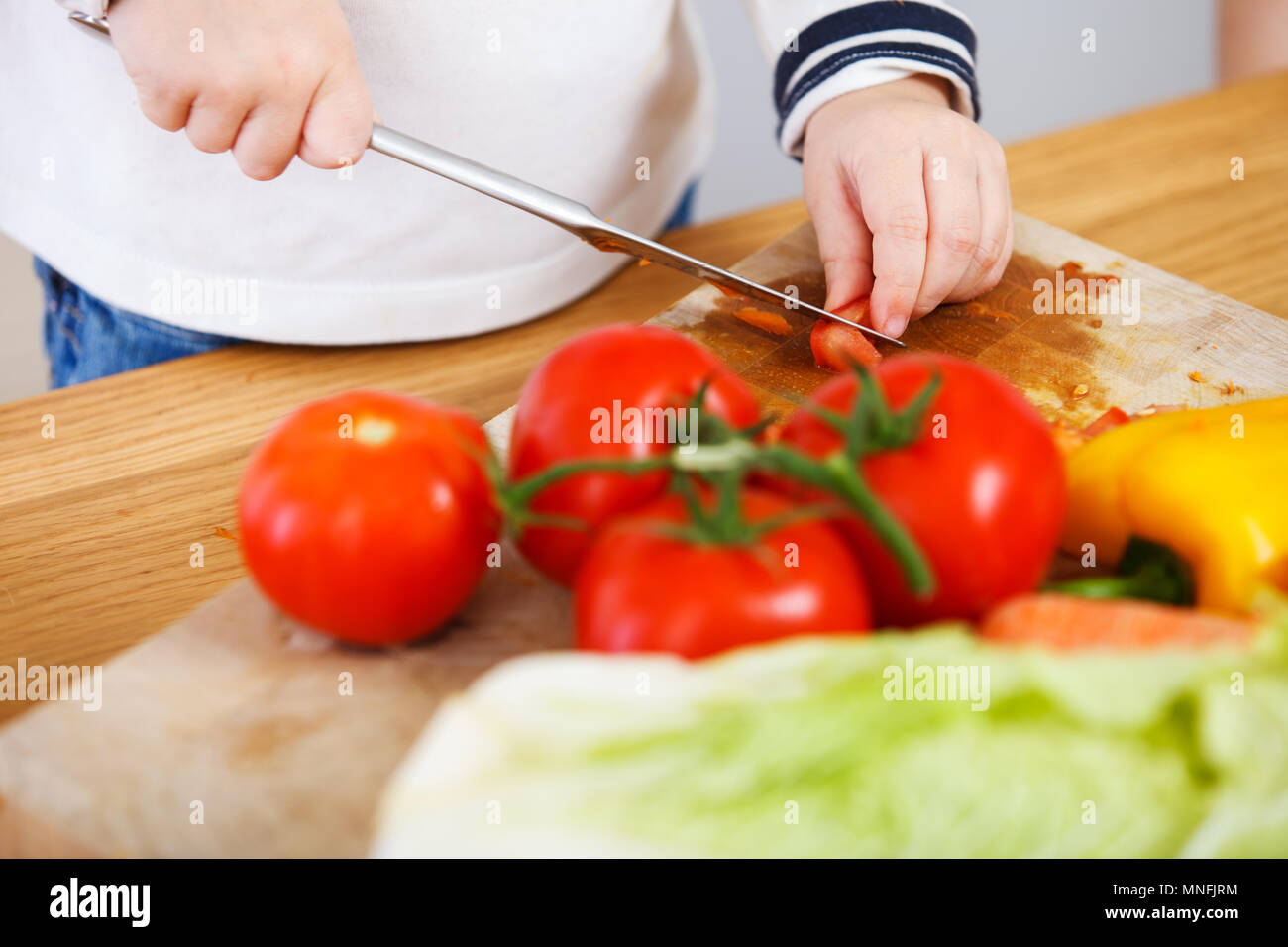 Close up of kid cutting vegetables for salad Stock Photo - Alamy