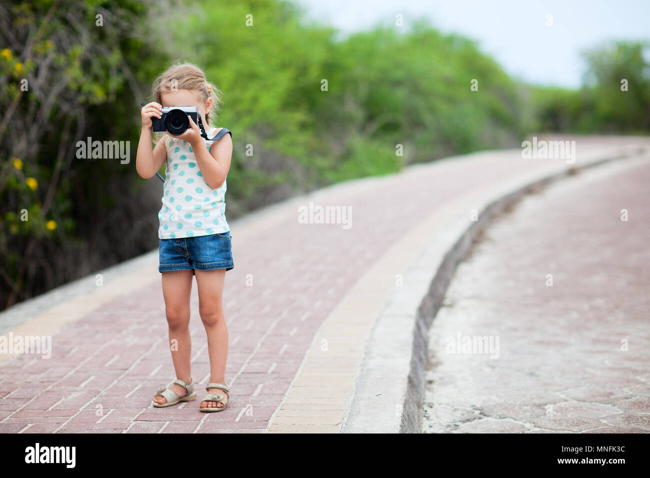 Adorable little girl with photo camera Stock Photo - Alamy